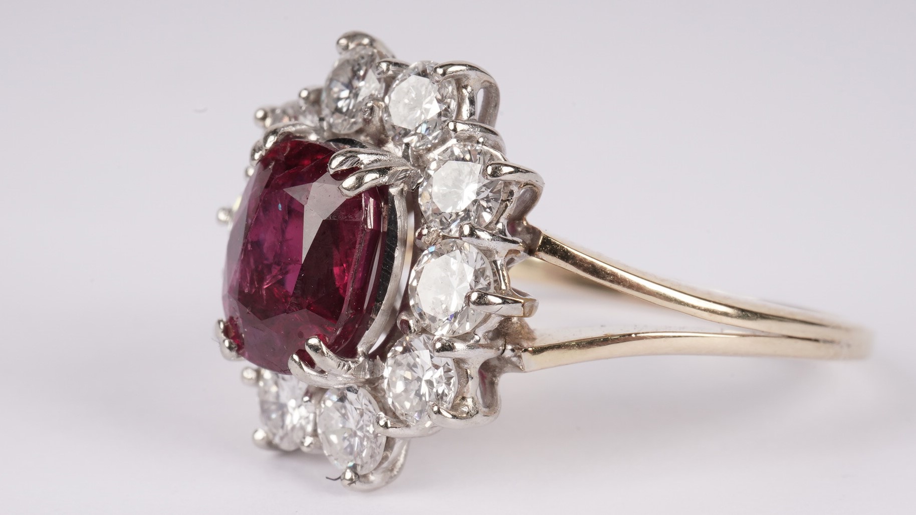 Lot 1076 - A ruby and diamond cluster ring