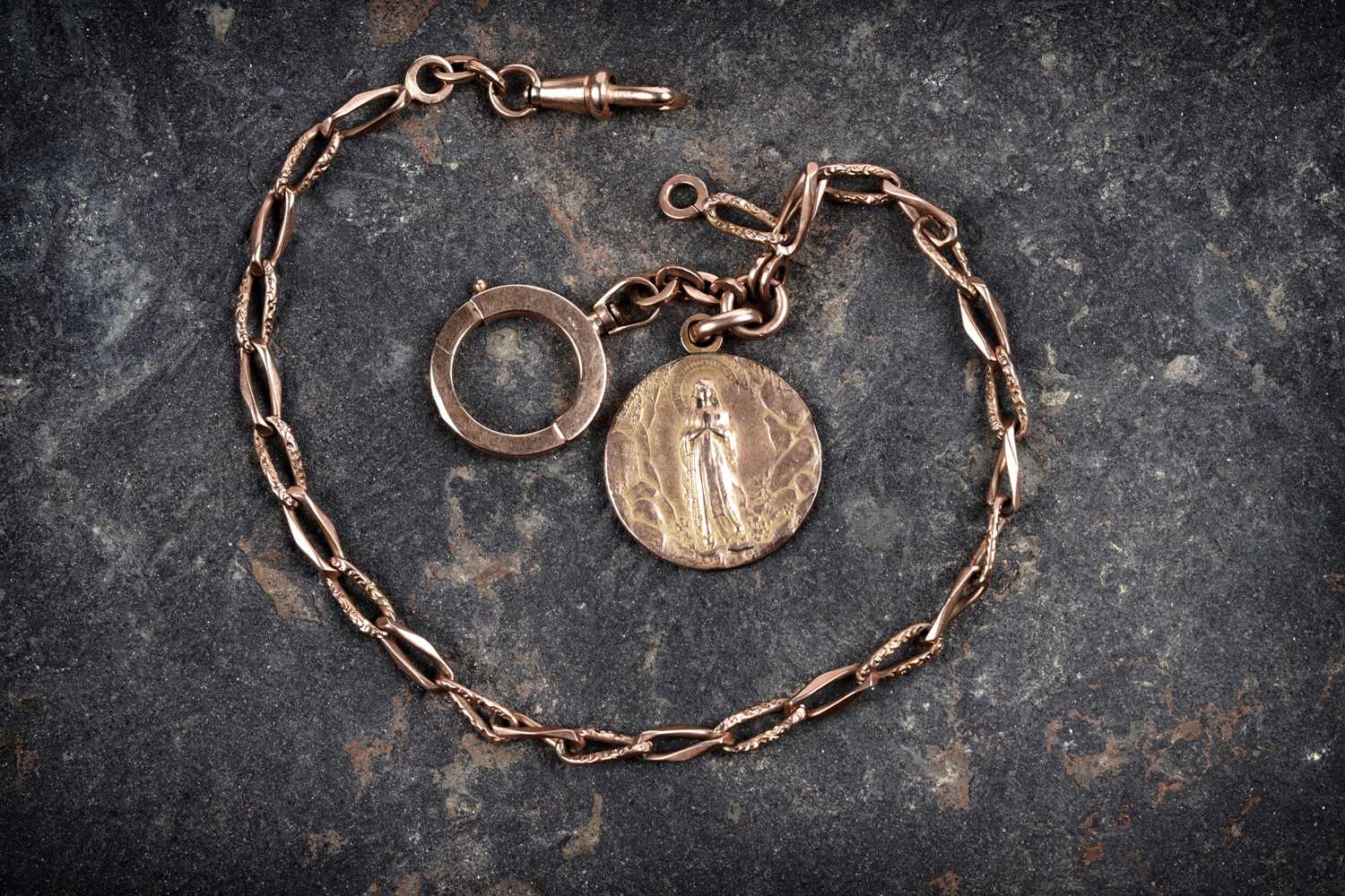 Lot 68 - A yellow metal watch chain, with religious